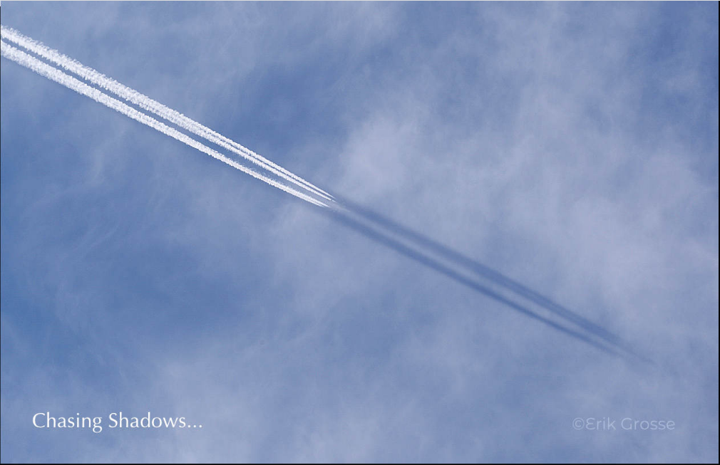 Contrail chasing its shadow across the sky